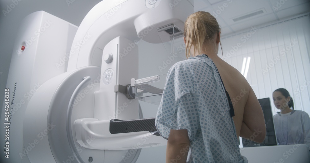 Hospital radiology room. Caucasian woman stands during mammography ...