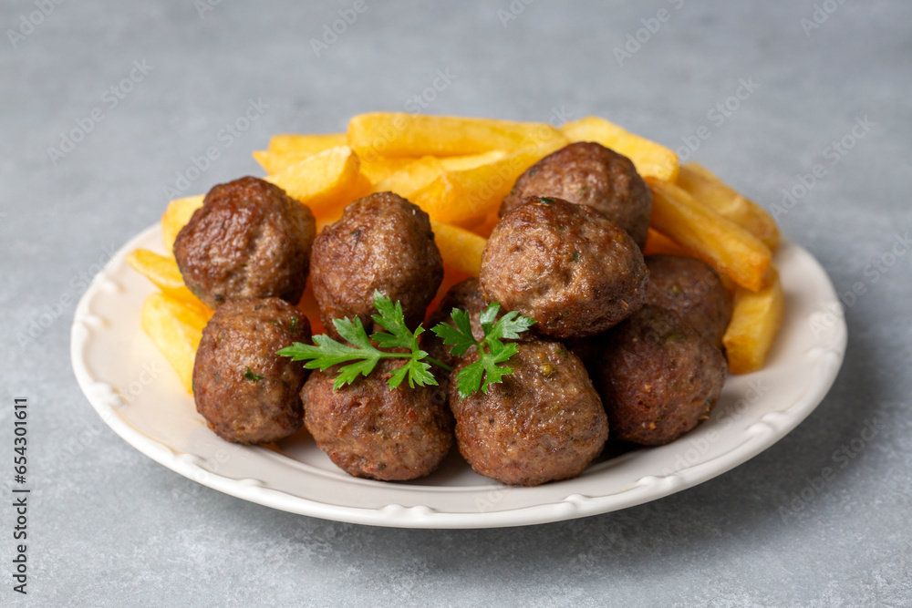 Round shaped balls of dry meatballs and french fries. Turkish name ...