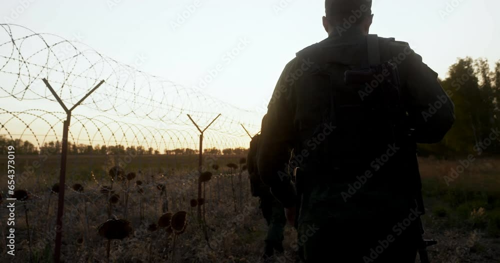 Two armed soldiers patrol border line with service dog, special ...