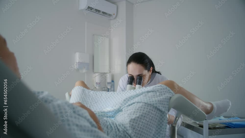 Gynecology room in hospital. Female gynecologist uses colposcope, takes ...