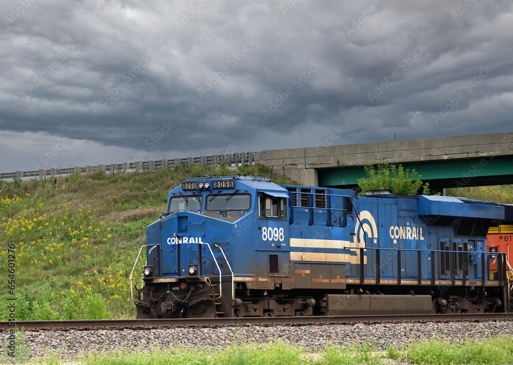 An off-road Norfolk Southern Railway heritage locomotive painted for the former Conrail leads a ...