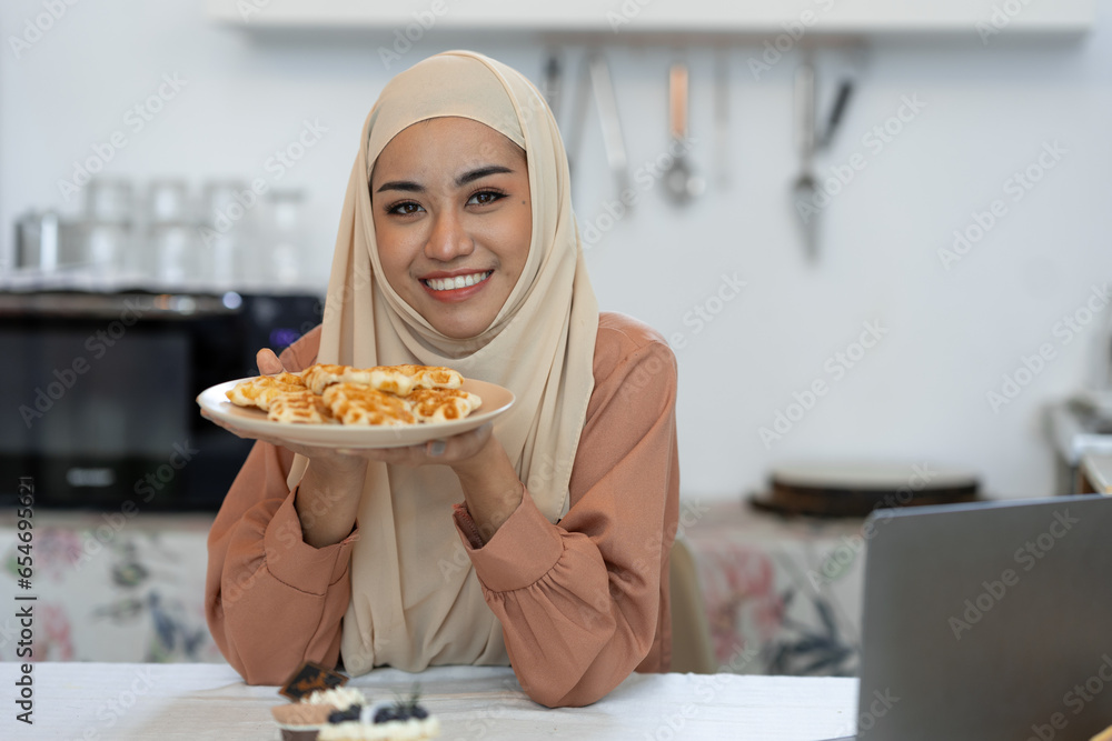 young muslim woman in hijab eating sweets, bread, waffles, cakes ...