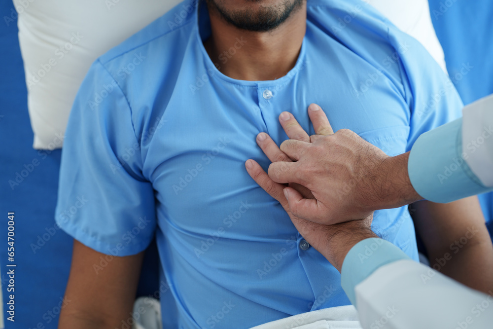 A male doctor uses his hands to pump a patient's heart with basic CPR ...