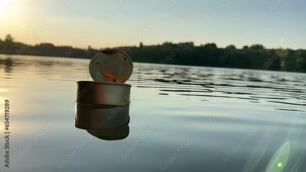 Tin can waste in lake water. Empty metal tin can garbage and food waste ...
