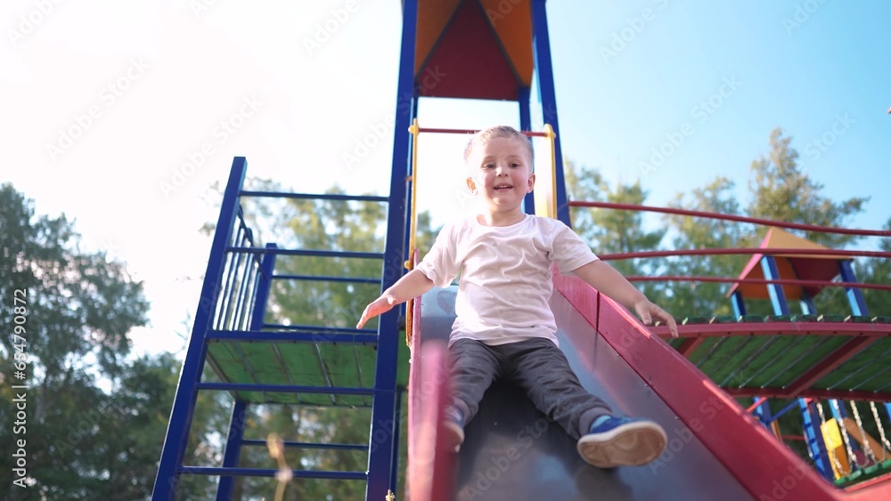 child slides down the slide on the playground. happy family kid dream ...