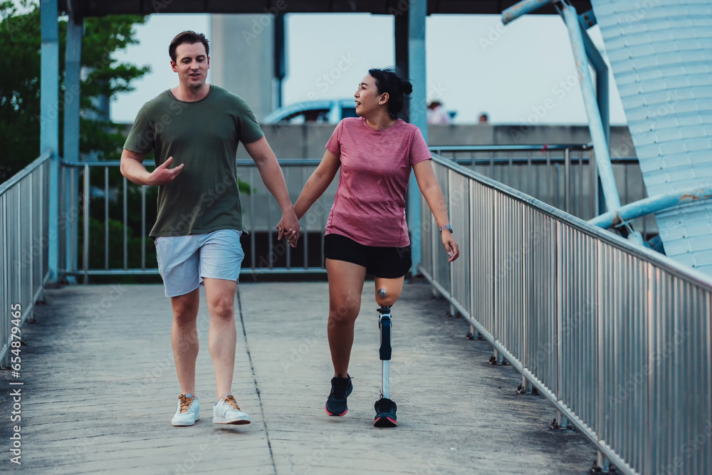 Friend support Friend with a prosthetic leg while exercising outdoor ...