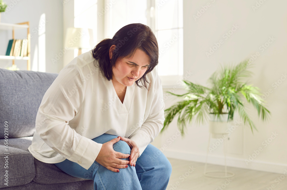 Foto de Overweight woman suffering from knee pain. Young fat girl with ...