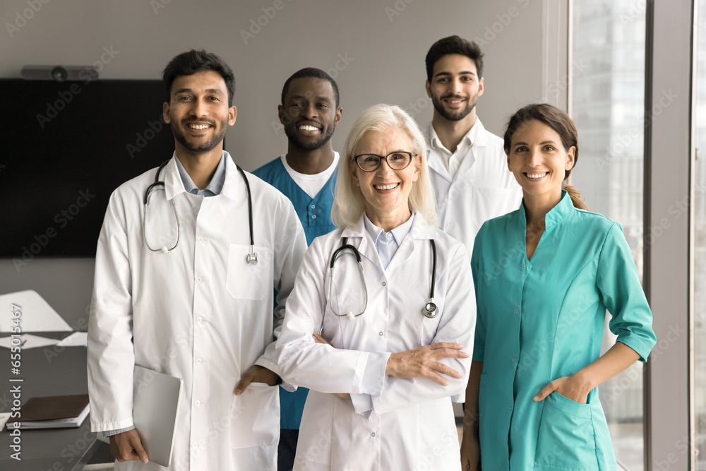 Positive confident senior clinic chief doctor and younger diverse team ...