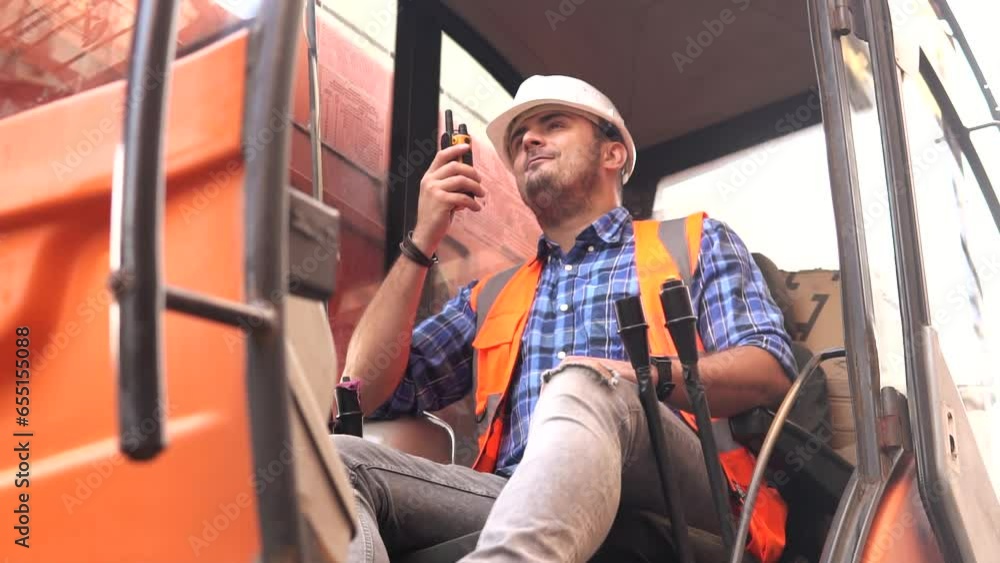 Young man loader worker or a forklift driver in a container warehouse ...