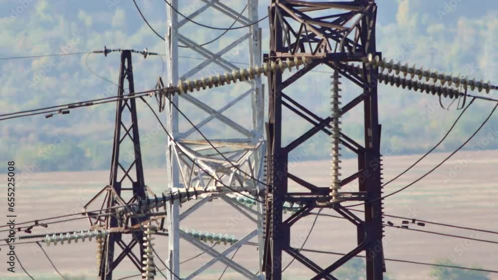 Overhead high-voltage power lines against backdrop of farmland and ...