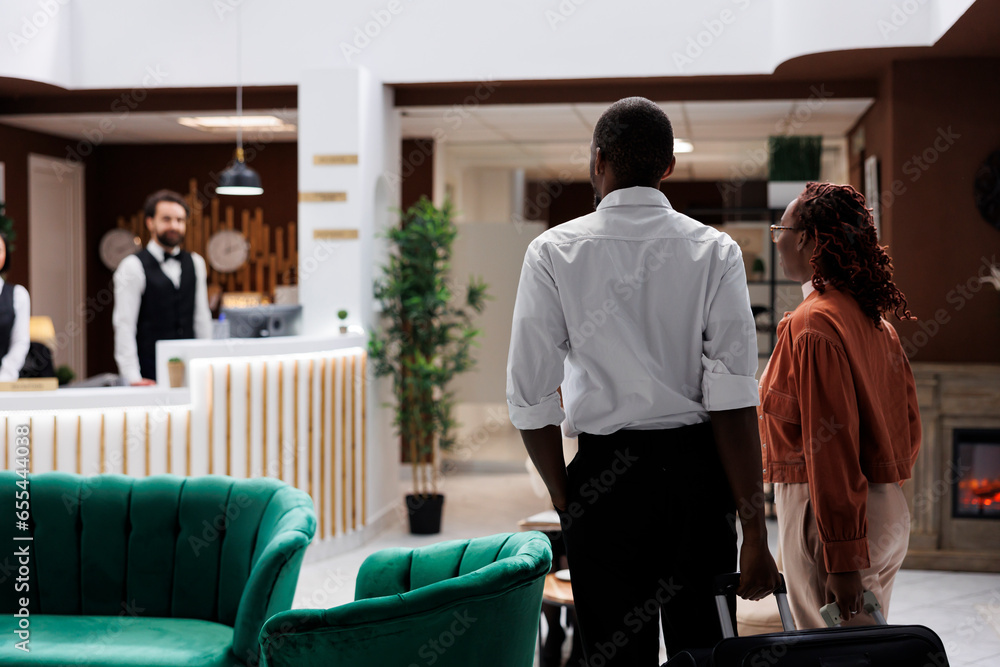 People arriving at luxury hotel lobby, entering lounge area and ...