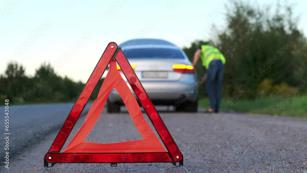 Broken silver luxury car emergency accident. Man driver installing red ...