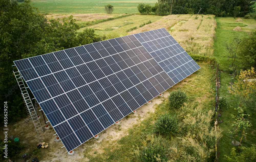 Aerial view of solar panels in green field at daytime. Different types ...