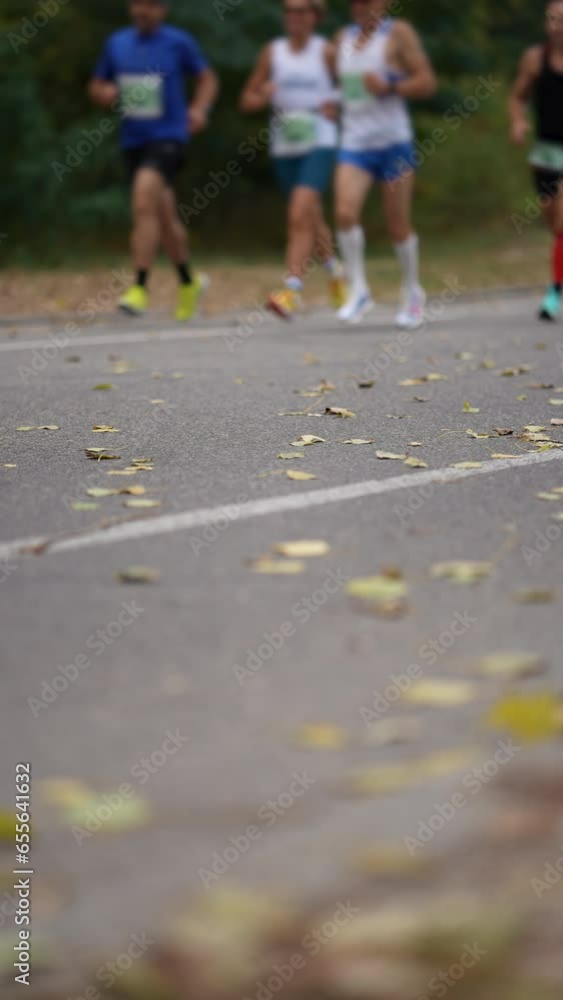 Vertical Screen: Slow motion unrecognizable athletes running marathon ...