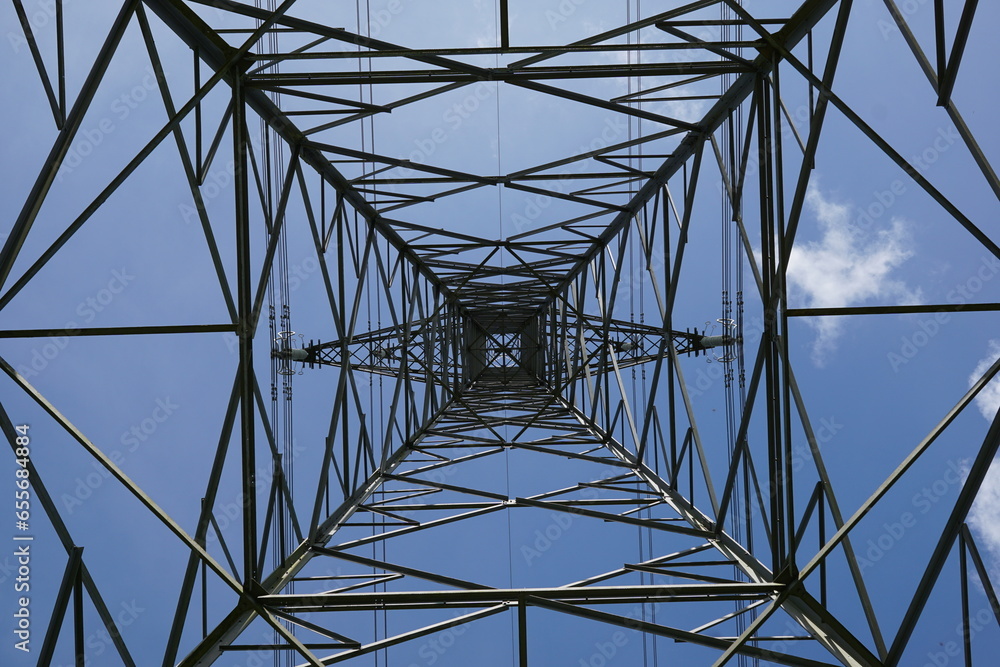 Symmetrical shapes of electricity pylon tower against blue sky ...