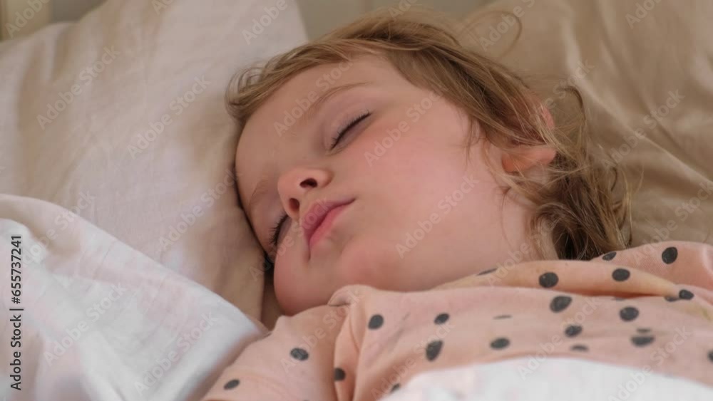 Peaceful adorable baby sleeping on a bed at home. Slumbering little child. Two years old girl ...