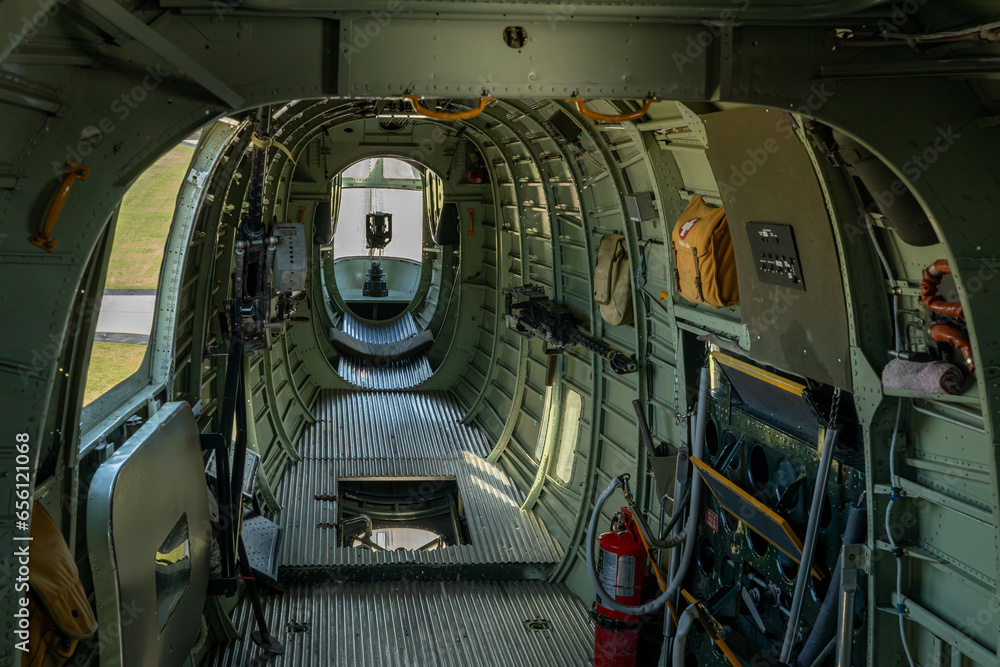 interior aft of B-24 bomber as it climbs away from an airport with view ...