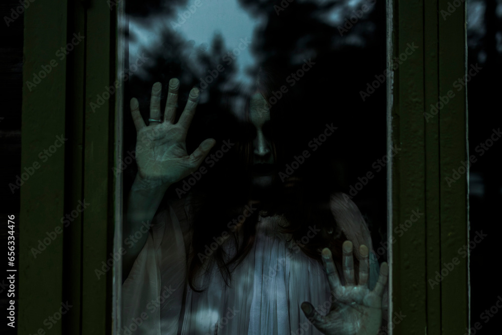 Spooky ghost looking through glass window of haunted cabin Stock Photo ...