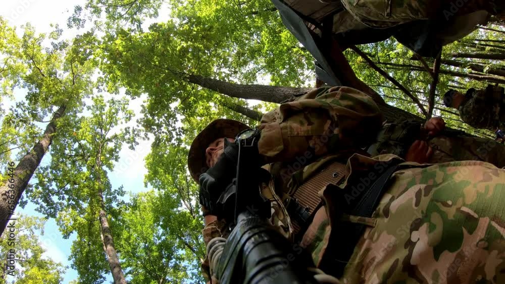 Vidéo Stock The camera on the bath of weapons. The military sniper in the helmet is attacking ...