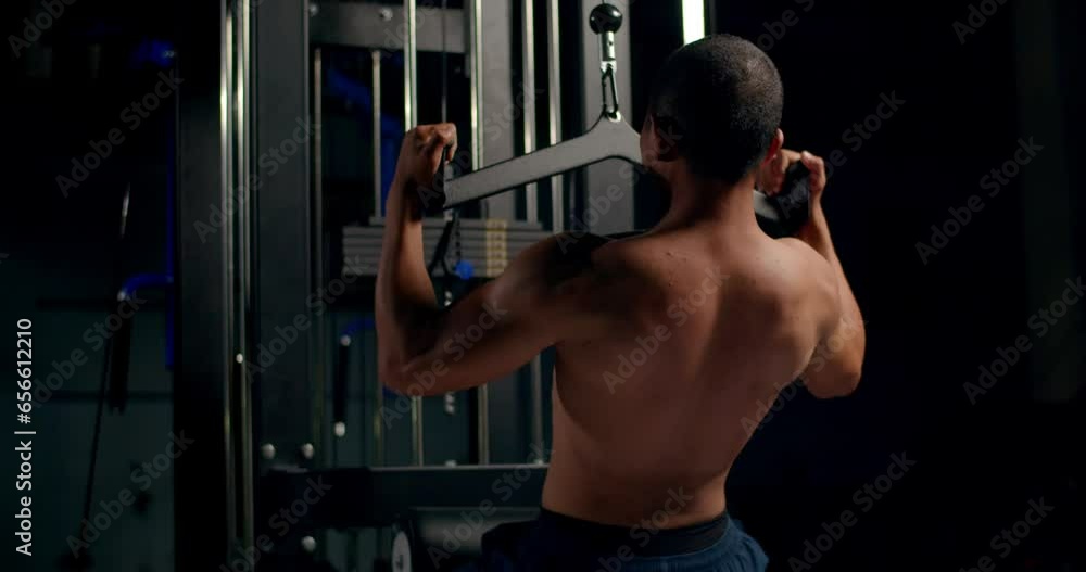 Rear view of asian man fitness exercises at gym lat pulldown machine ...