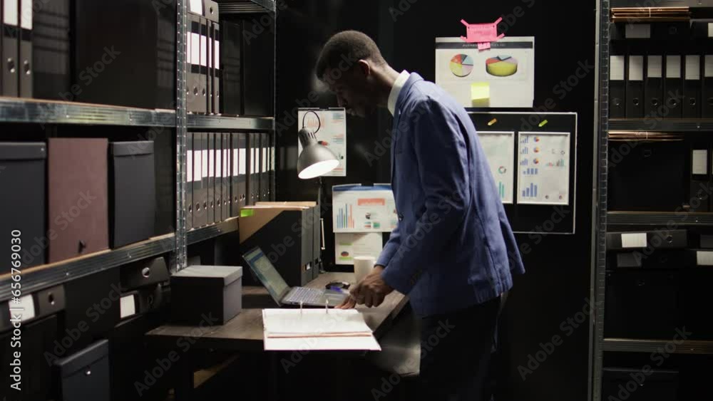 In neatly organised office, african american detective examines ...