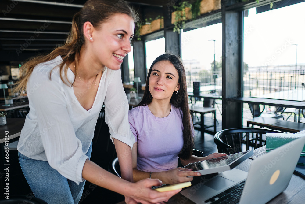 Two young women working together on sustainable resources project at ...