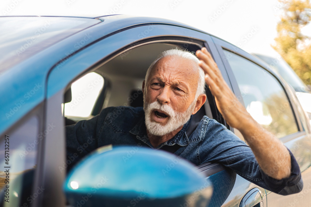 Angry man driving a car. The old men with an expression of displeasure ...