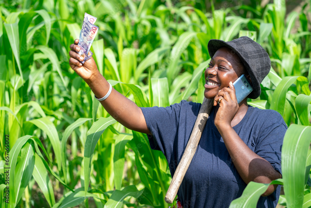 image of excited african lady holding african currency and a smartphone ...