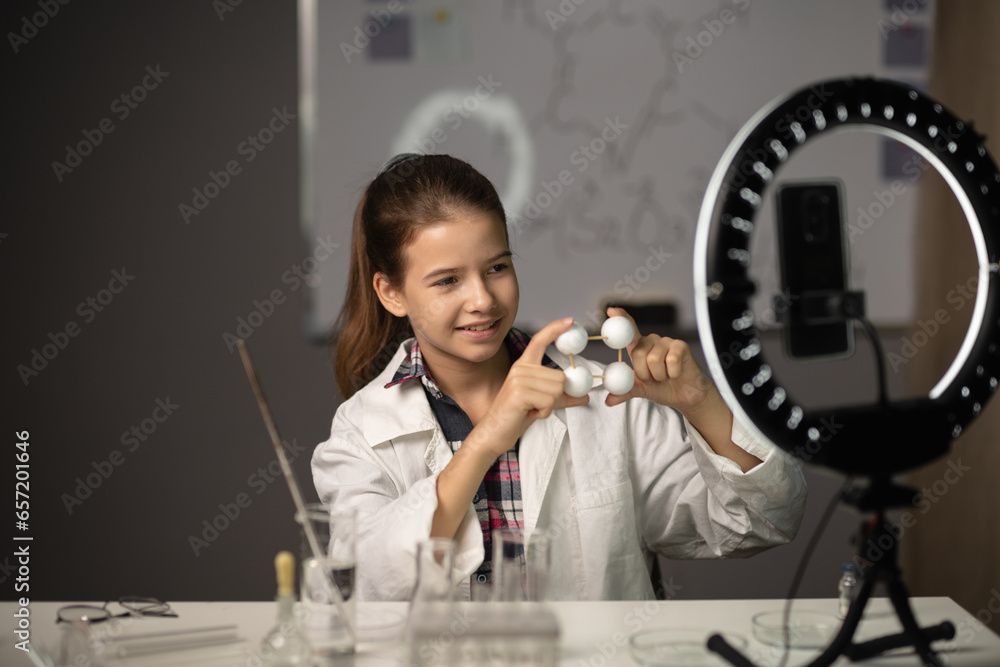 Science student recording learning blog holds model of molecular ...