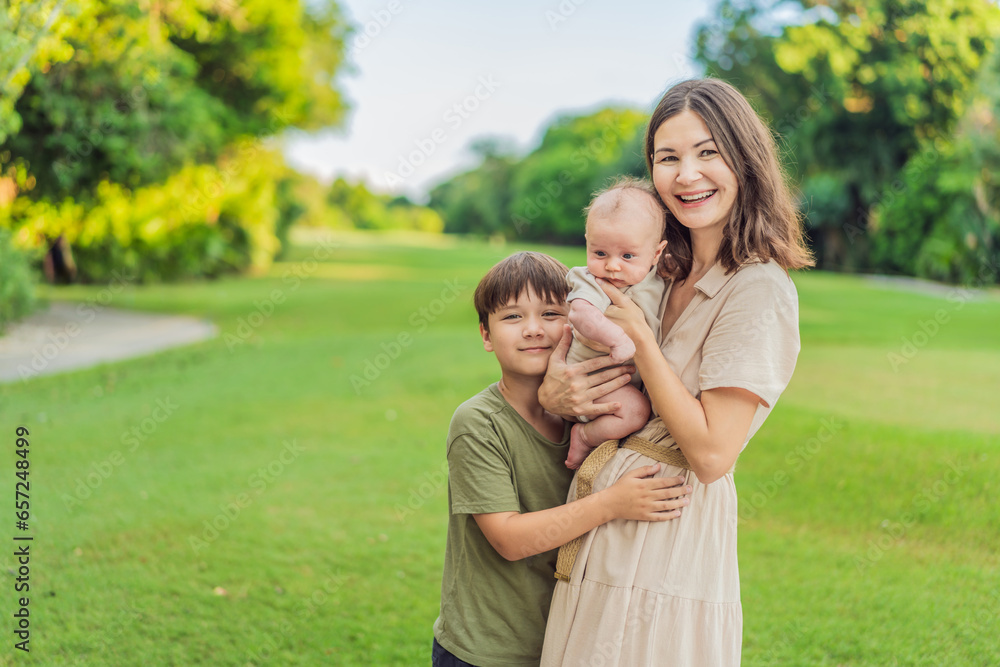 A happy 40-year-old mother cradles her newborn with her adult son in a ...