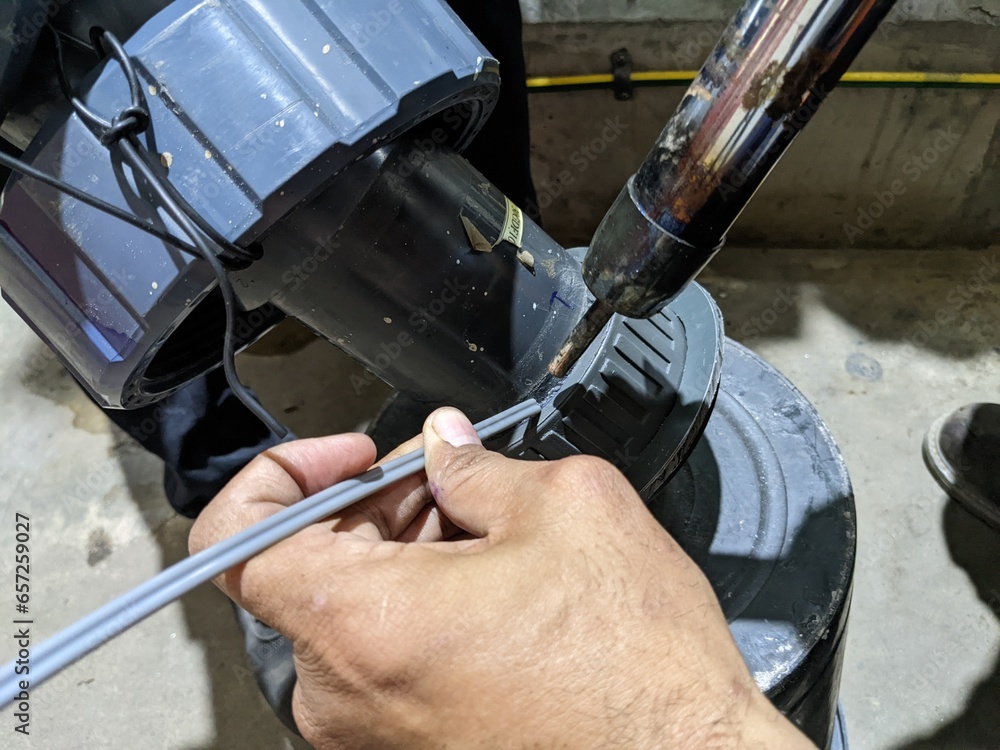 Welding PVC material for rectify leakage on PVC pipe line. The photo is ...