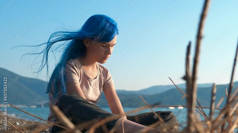 Sad teenager on the beach. A sad teen girl with fashioned hair style ...