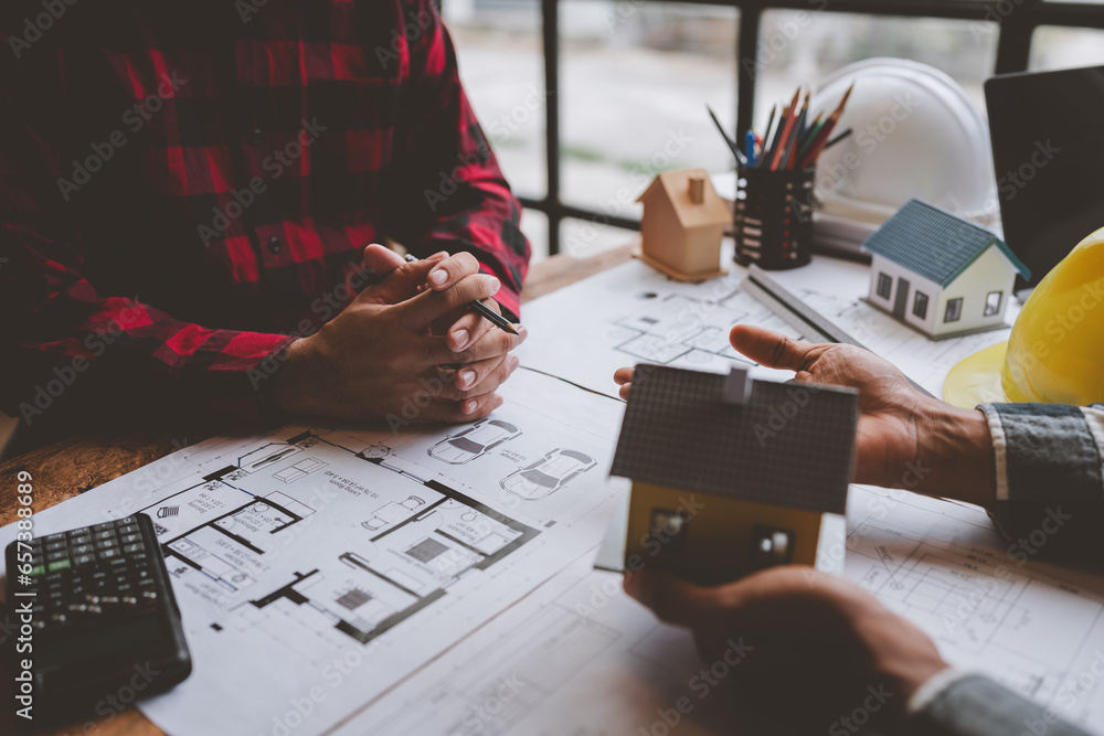 Two young Asian businessmen or architects are describing architectural ...