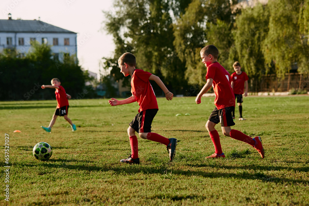 Full length photo of kids, football players in sport uniform training ...