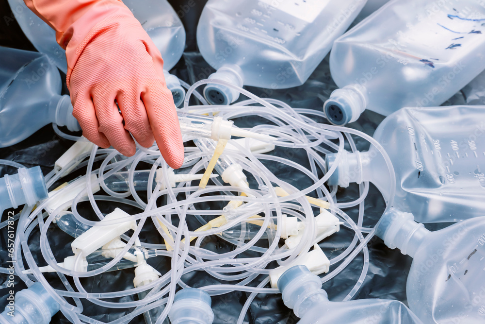 Hands of female officers sorting toxic waste, IV tubes, extension tubes ...