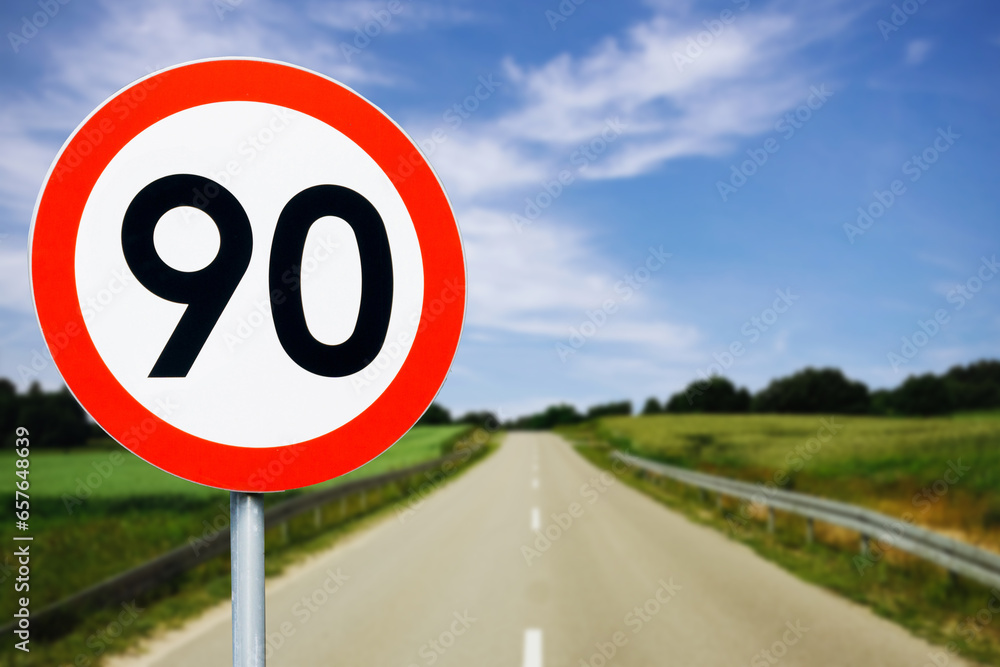 Speed limit sign with trees behind. Maximum ninety kilometers per hour ...