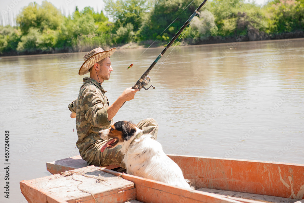 Calm male fisher throwing hook into water, while sitting in rowing boat ...