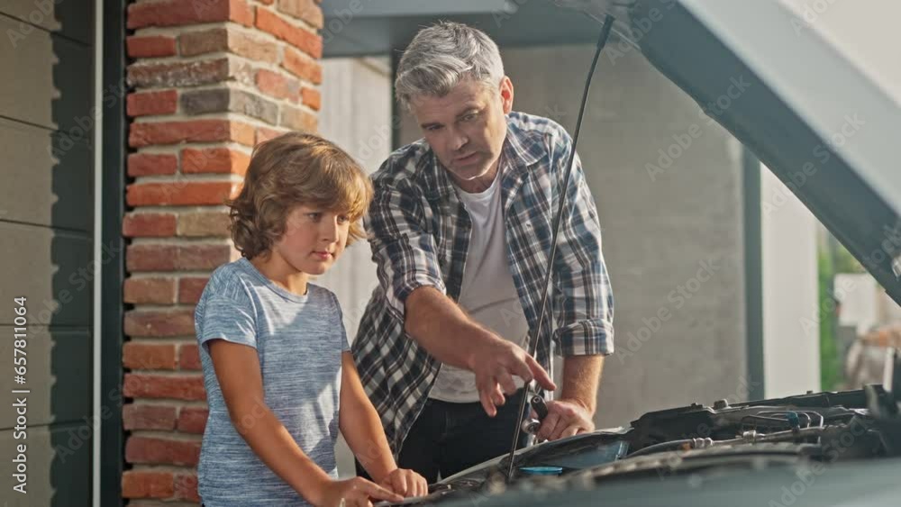Little Caucasian child helping his loving father diagnosing broken car ...