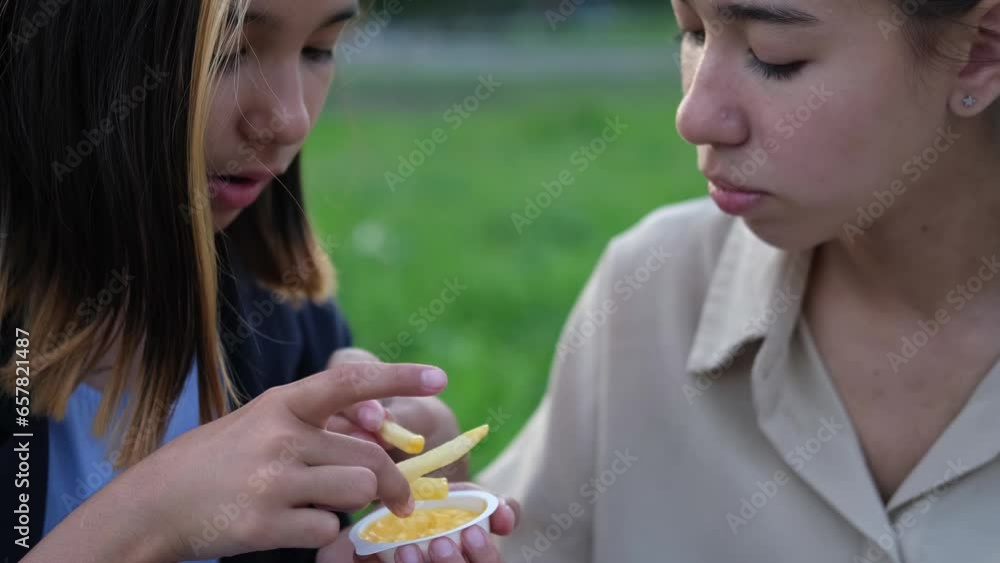 Cute children, two sisters eating French fries outdoors in summer ...