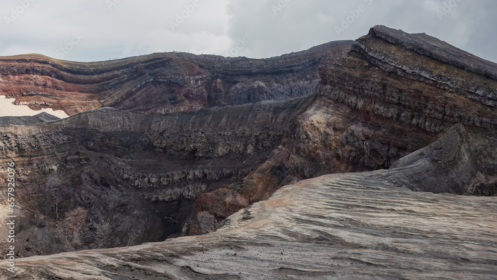 Mountain landscape. The rim of a volcano crater. Layers of rocks on the ...