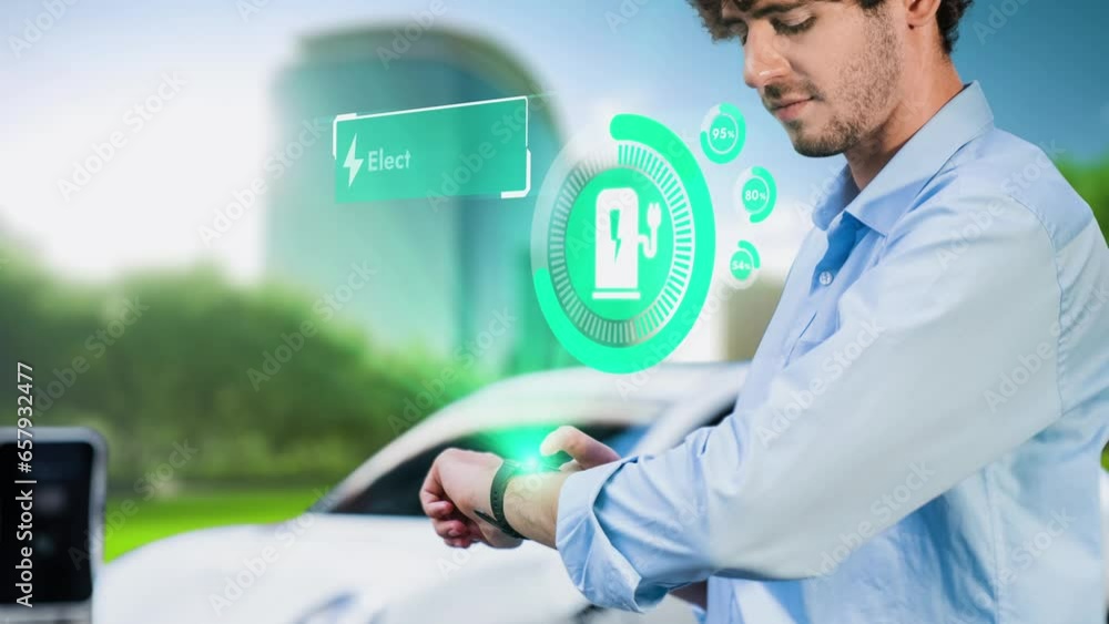 Businessman check EV car battery status on smartwatch hologram recharge ...