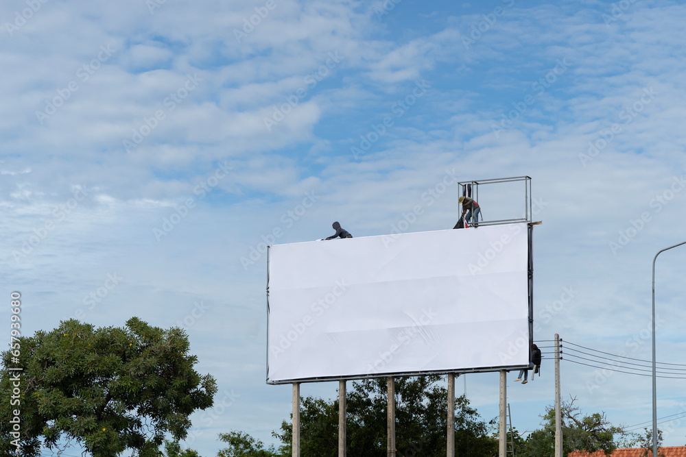 Worker prepares billboard to installing new advertisement. Industrial ...