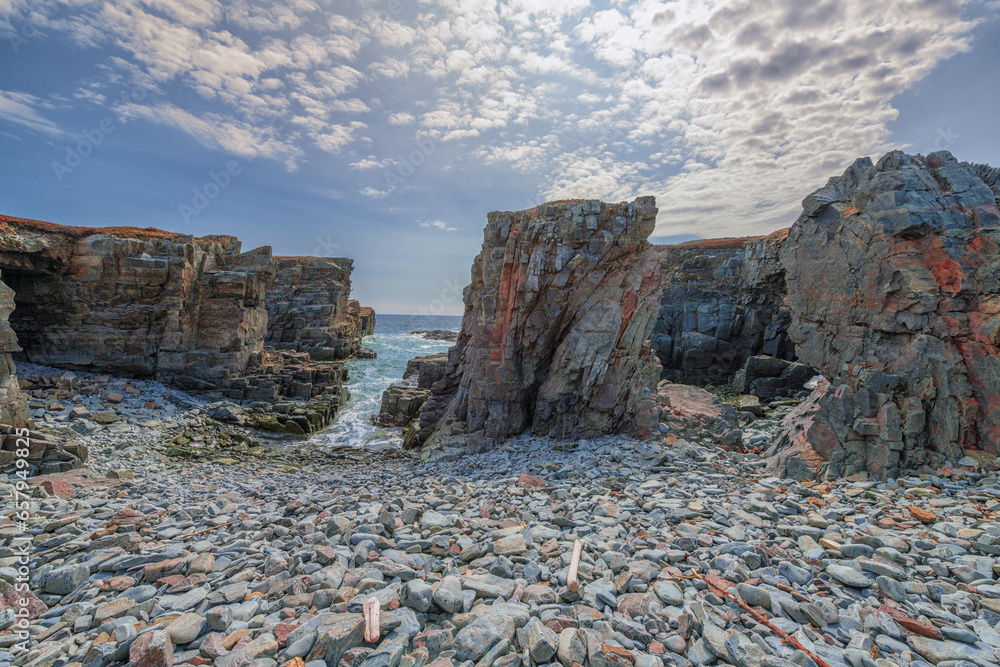 Vertical columns of rock stacked along Newfoundland shoreline and ...
