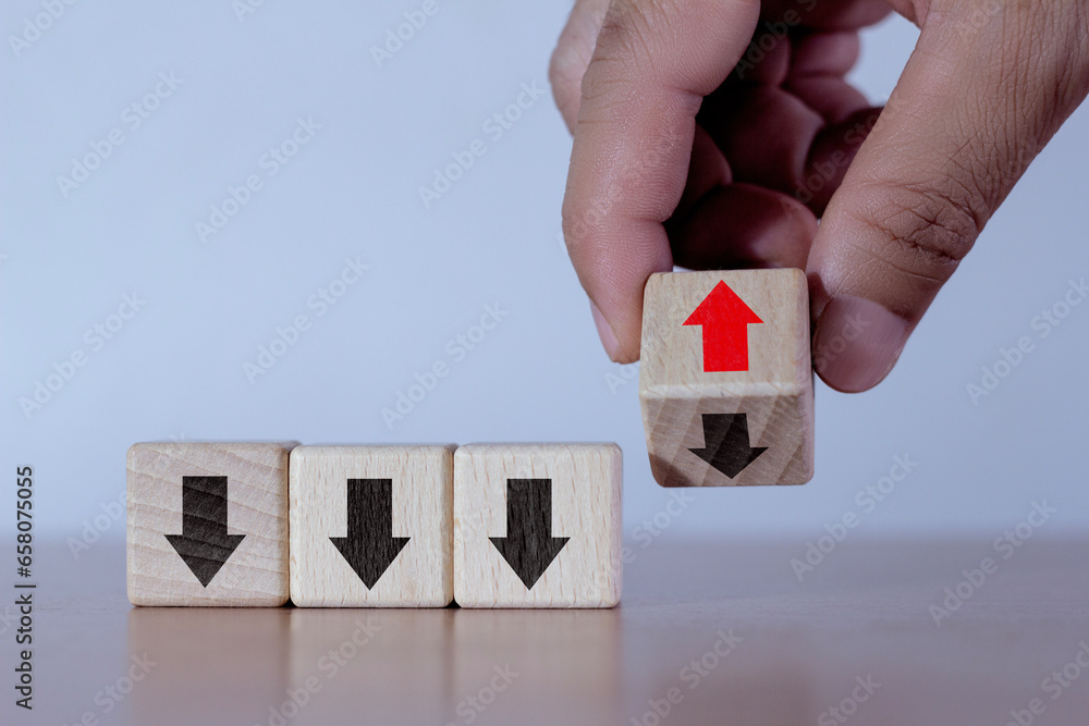 Hands flip over wooden blocks with arrows, one of which moves forward ...