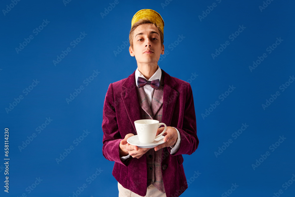 Full-length image of young guy, bell boy, hotel porter serving coffee ...