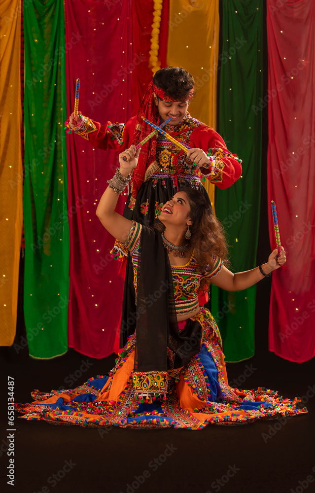 Indian couple dressed in cultural attire doing garba folk dance with ...
