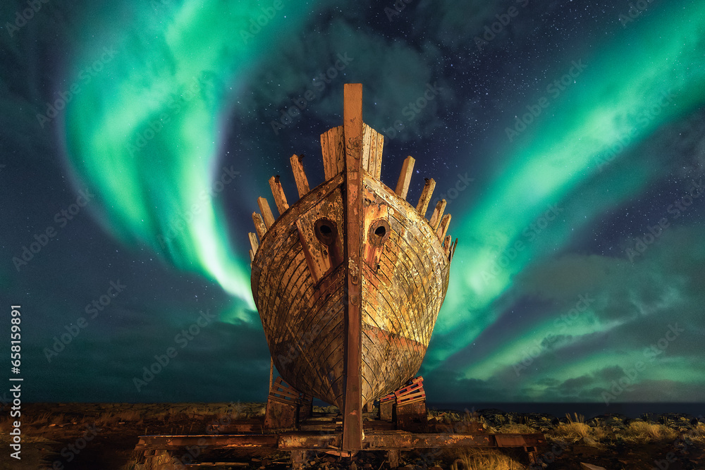 Northern Lights (Aurora Borealis) dancing across the sky over an old ...