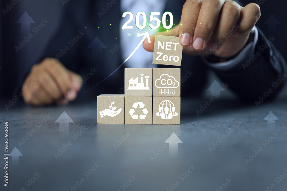 Businessman stacking wooden dice on campaign to reach zero CO2 carbon ...