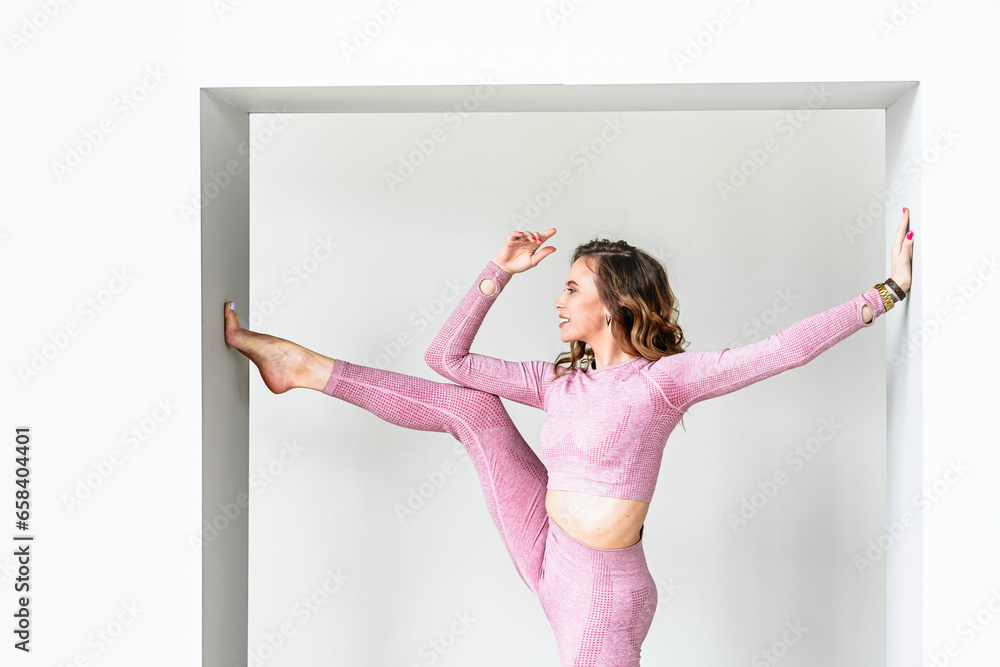 Slim woman training yoga poses, asanas in pink tight-fitting tracksuit ...