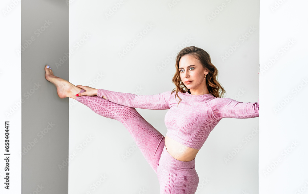 Slim woman training yoga poses, asanas in pink tight-fitting tracksuit ...